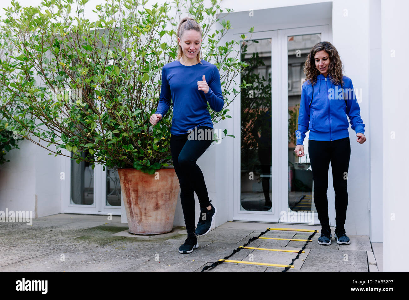 Two young women doing agility ladder exercise on a terrace Stock Photo ...