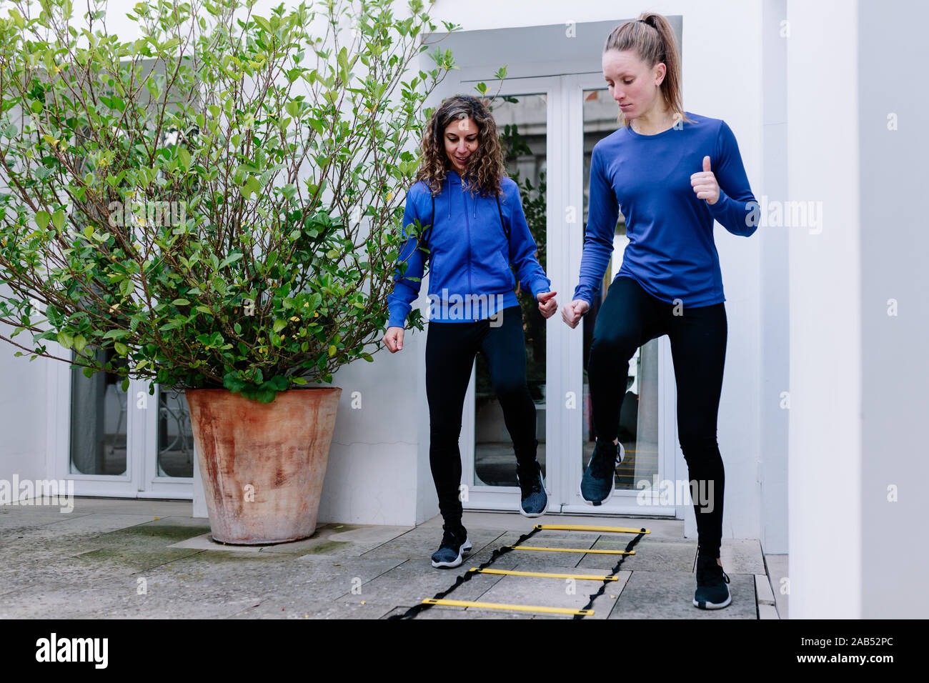 Two young women doing agility ladder exercise on a terrace Stock Photo ...