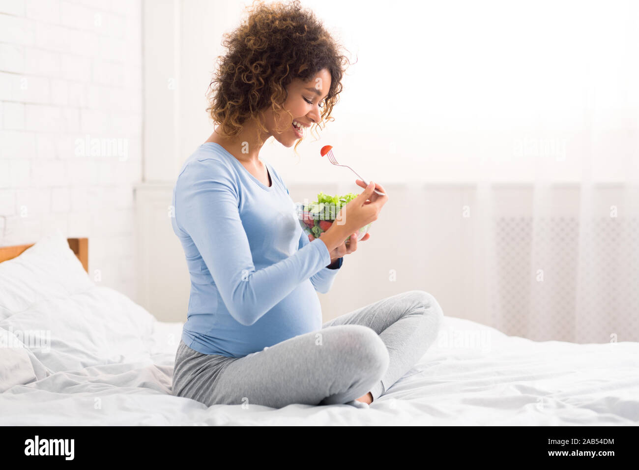 African-american expectant girl enjoying healthy vegetable salad Stock ...