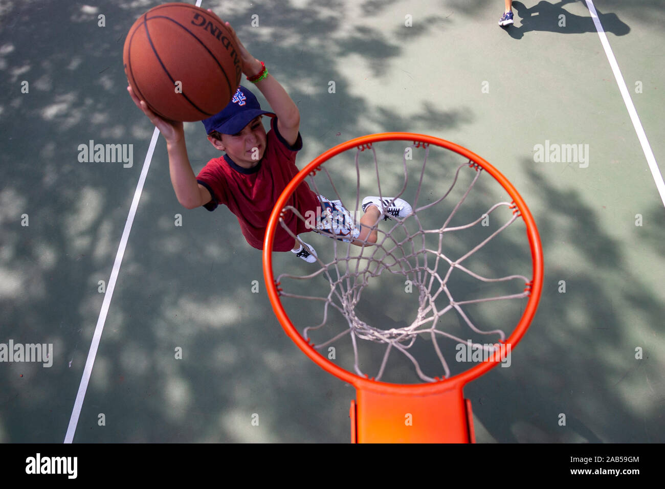 Boys dunking basketball at day camp Stock Photo - Alamy