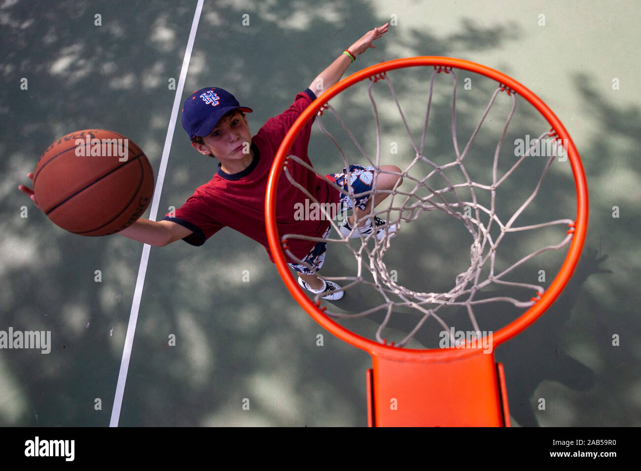 Boys dunking basketball at day camp Stock Photo - Alamy