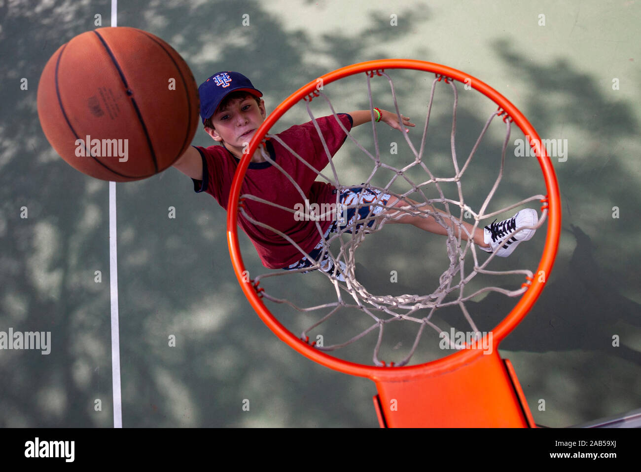 Boys dunking basketball at day camp Stock Photo - Alamy
