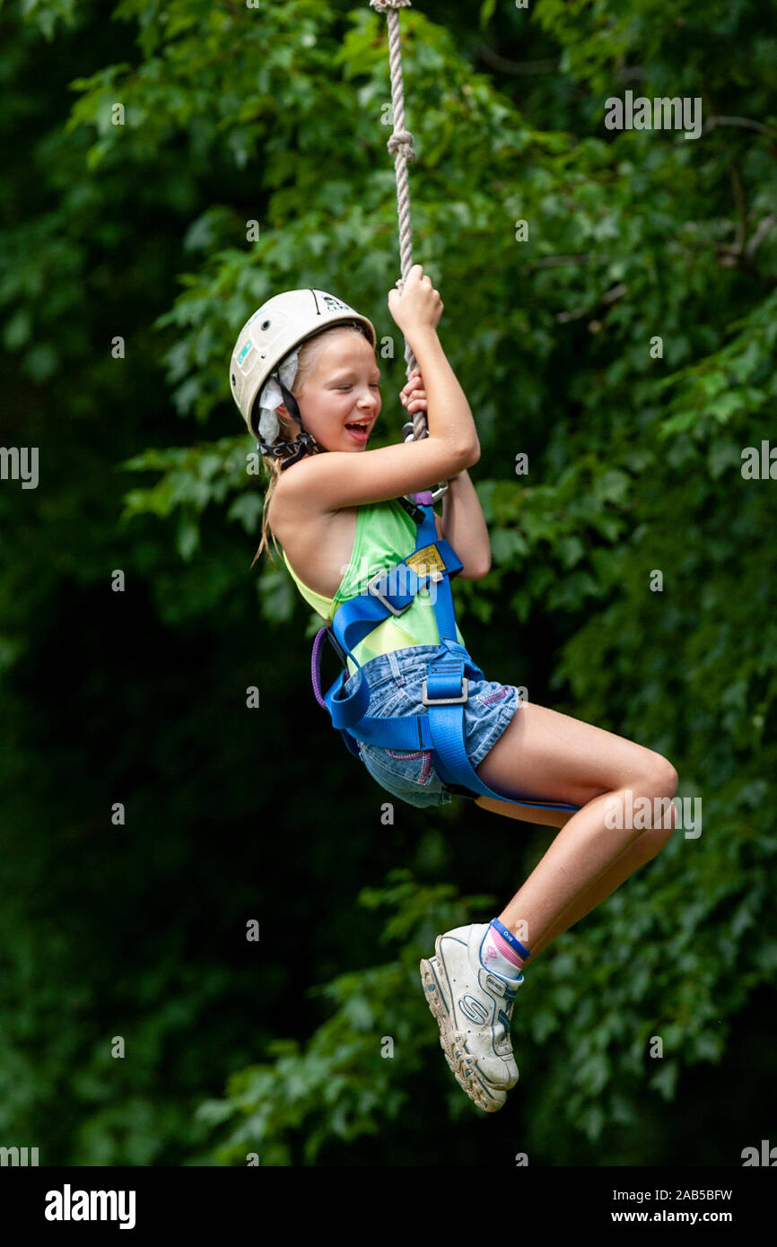 Girl on zip line at day camp Stock Photo - Alamy