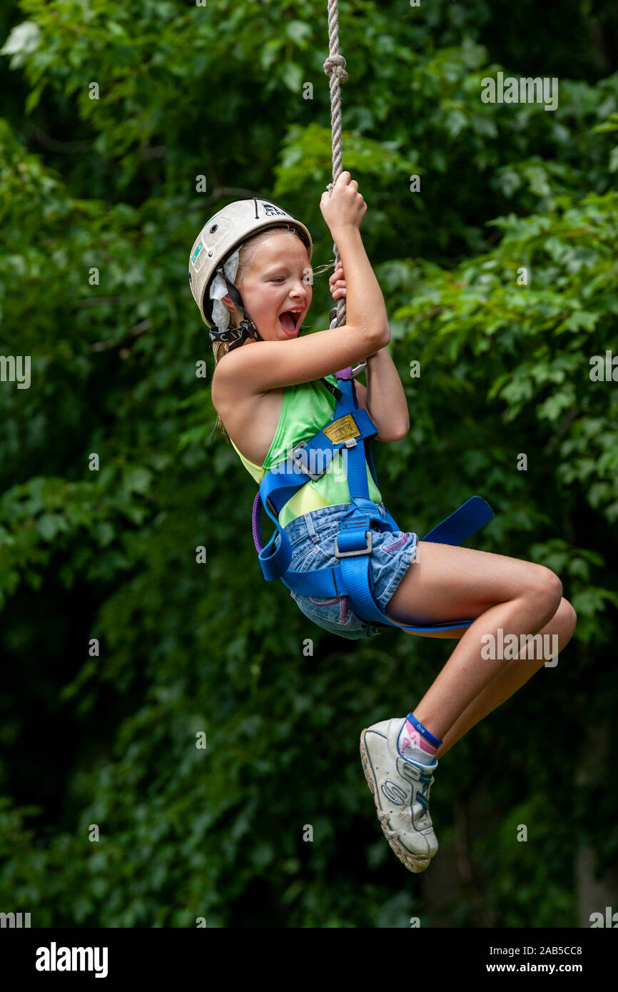 Girl on zip line at day camp Stock Photo - Alamy