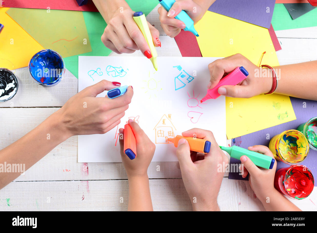 Hands hold colorful markers and draw. Markers in male and female hands ...