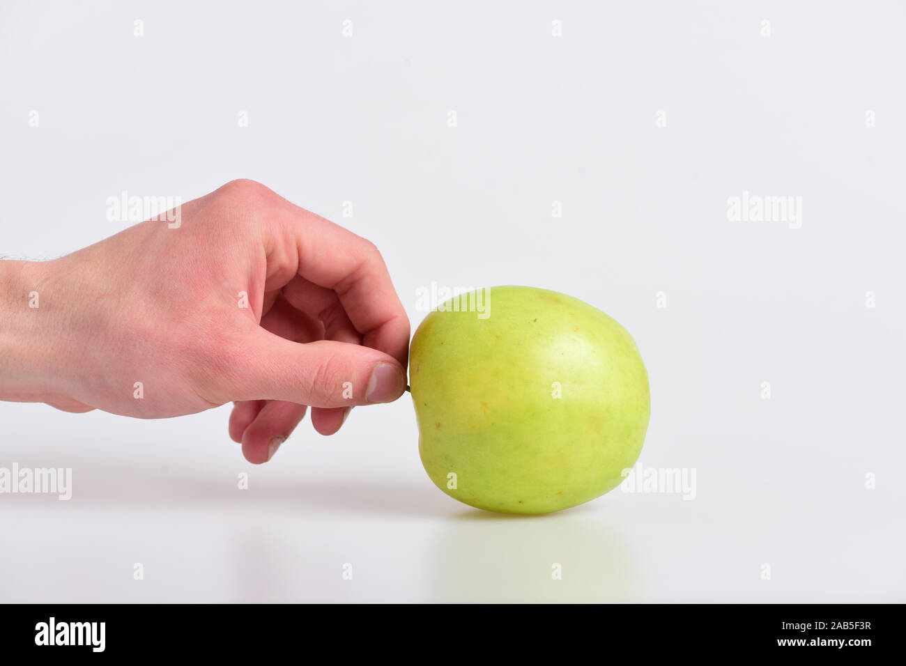 Male hand holds green apple. Apple in fresh and juicy color. Food and ...