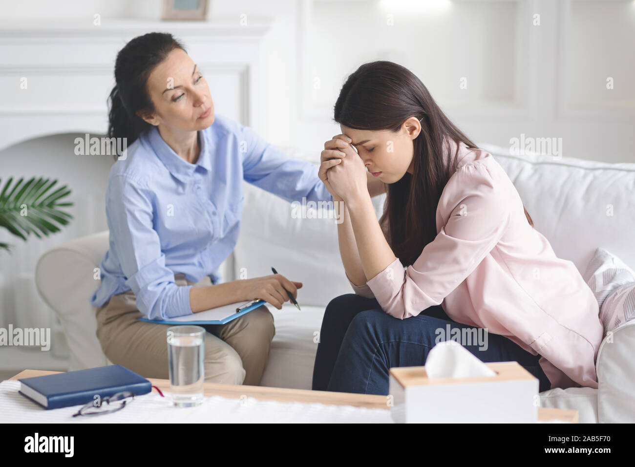 Therapist comforting her depressed crying woman patient Stock Photo - Alamy