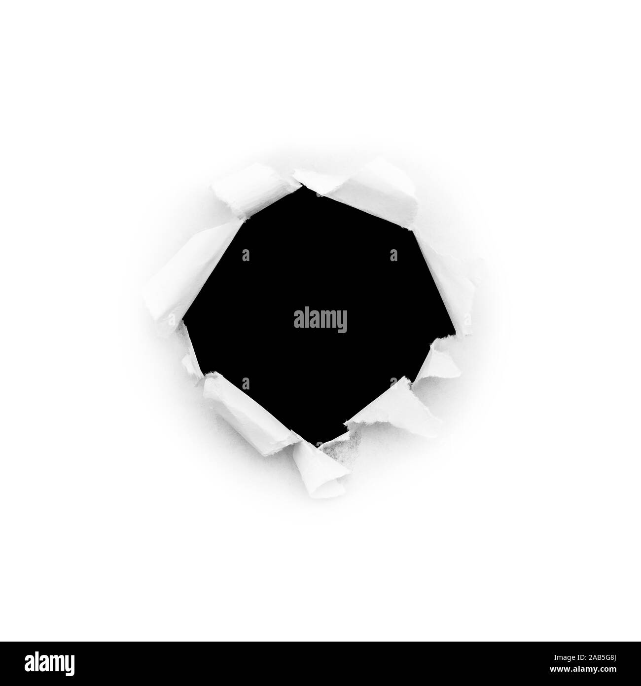 A round hole in white paper with torn edges isolated on a white ...