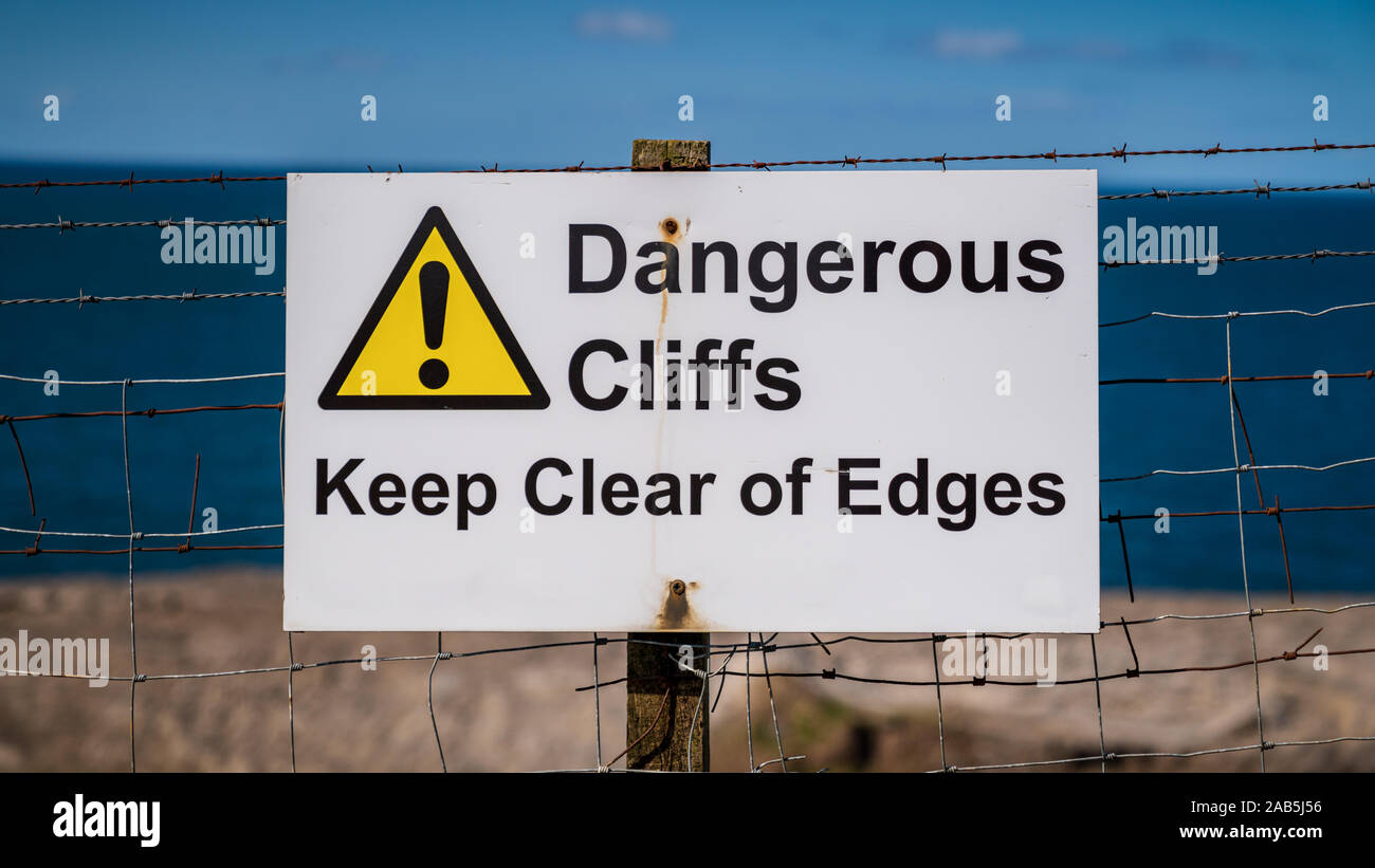 Sign: Dangerous Cliffs, Keep clear of edges - with barbwire and the ...