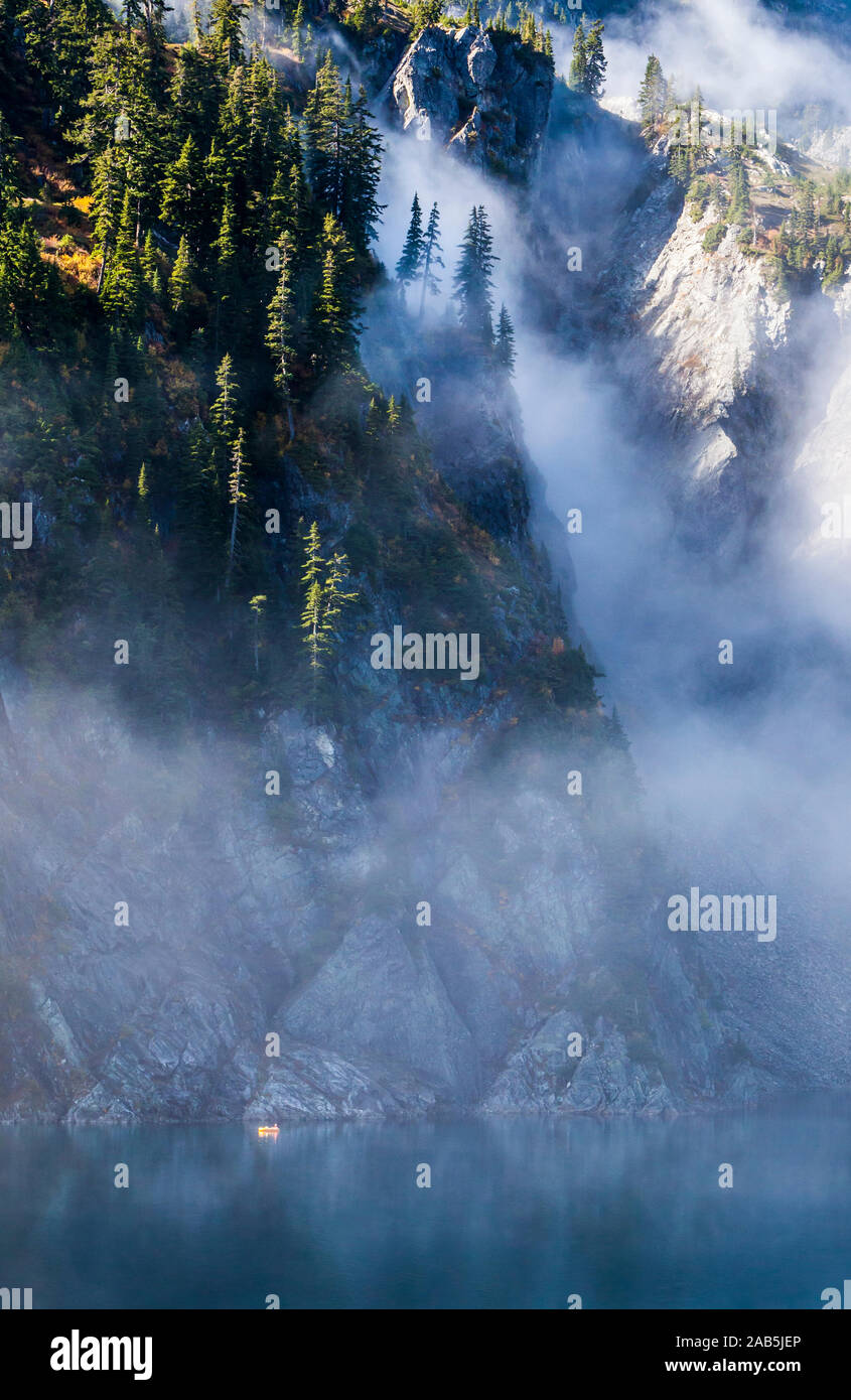 A man in a small inflatable raft rowing on Snow Lake above Snoqualmie ...