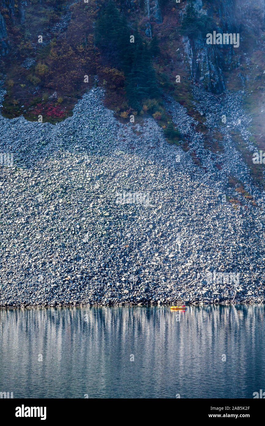 A man in a small inflatable raft rowing on Snow Lake above Snoqualmie ...
