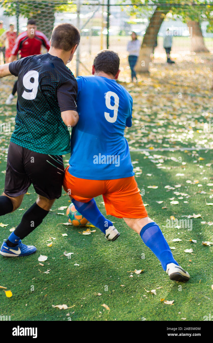 Two soccer players perform an action play on a soccer field. All ...