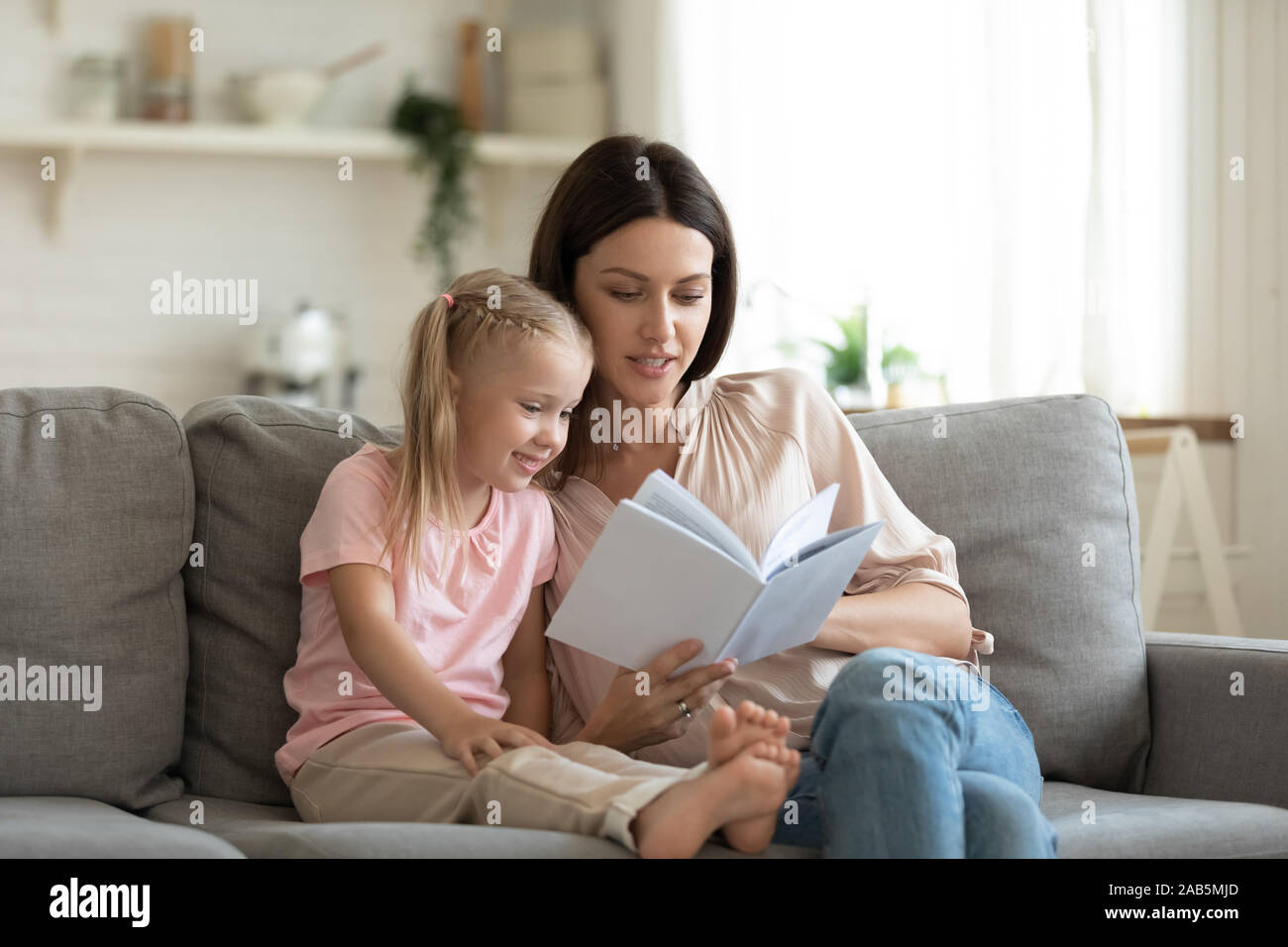 Young mom reading book teaching smart preschool kid daughter Stock ...