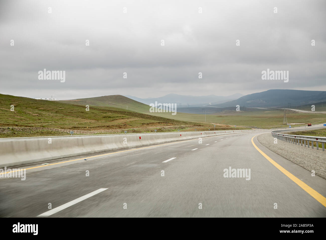 road receding into the distance in open countryside under a cloudy ...