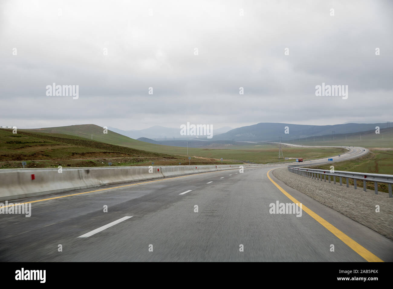road receding into the distance in open countryside under a cloudy ...