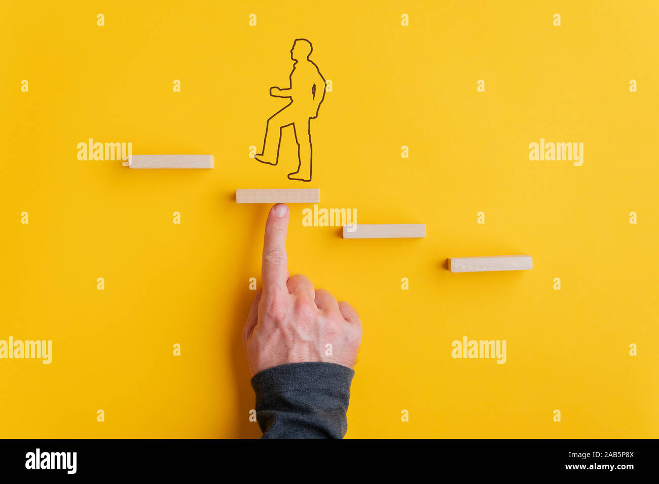 Male hand supporting a step in metaphorical stairway for a silhouetted ...