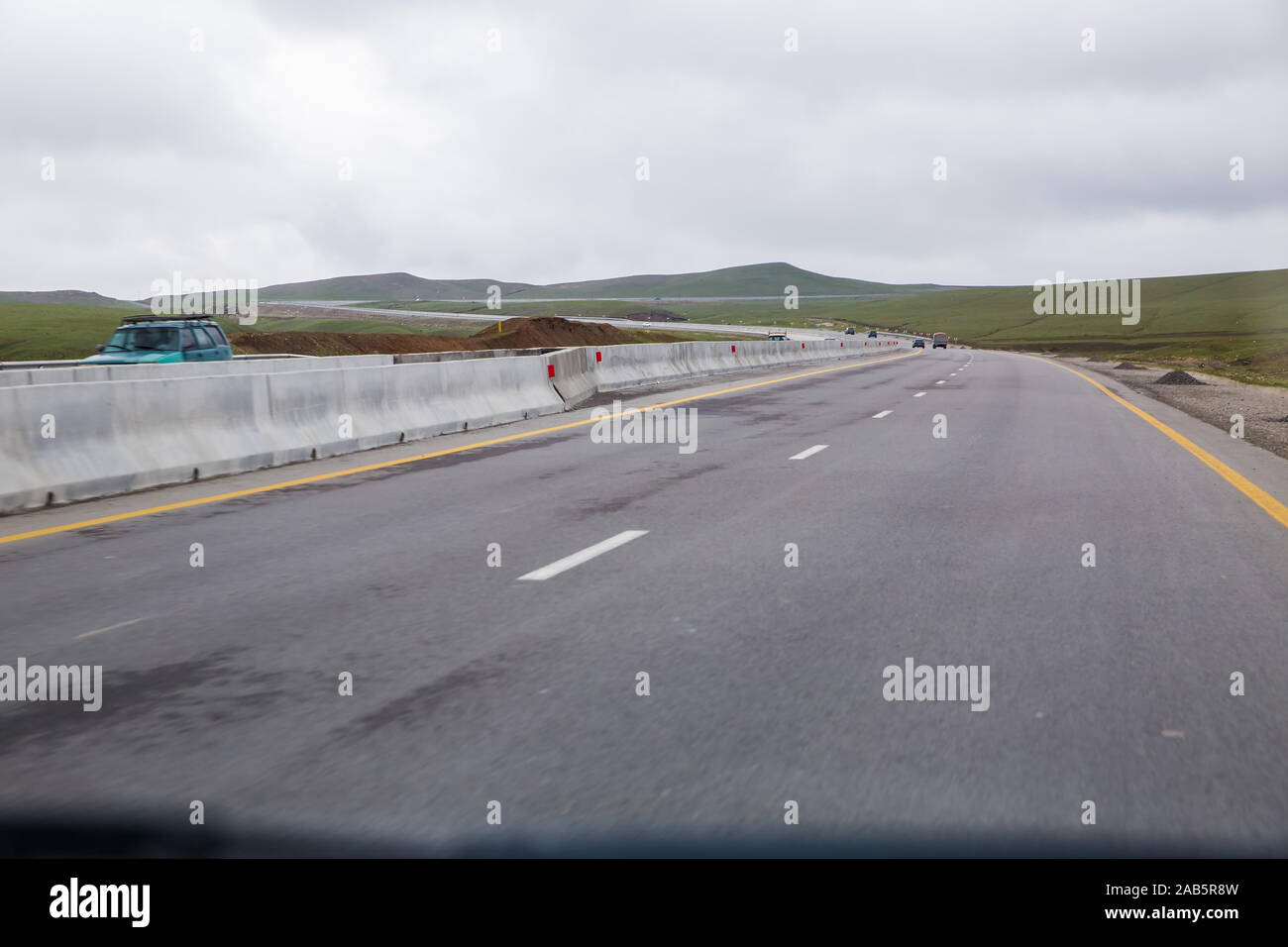 road receding into the distance in open countryside under a cloudy ...