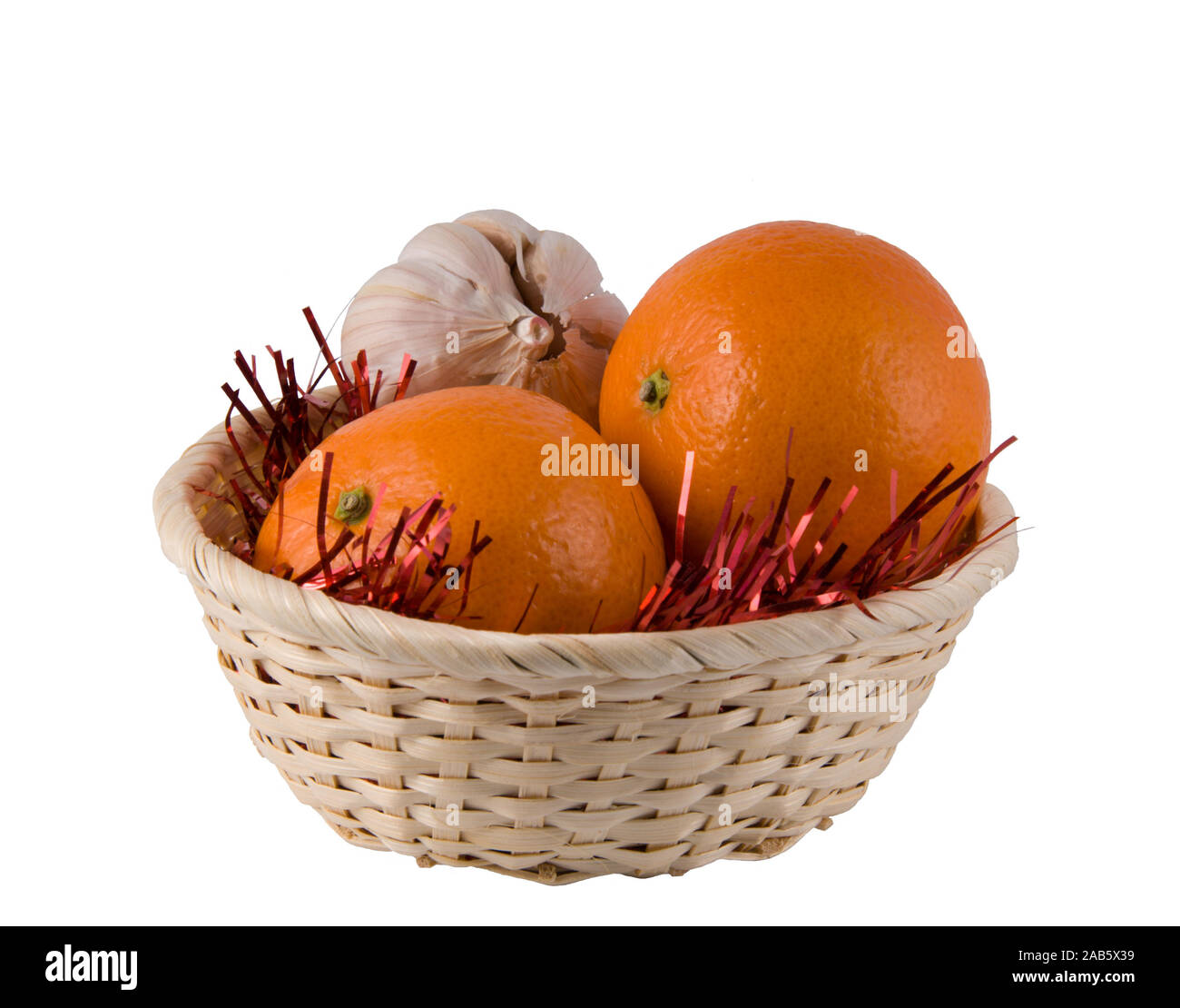 Two ripe oranges and one head of garlic in a wum basket on white ...
