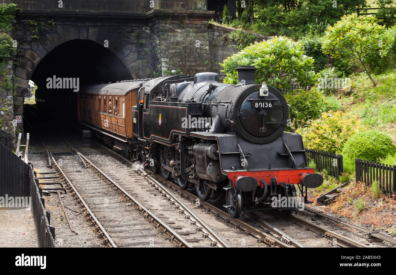 A steam train emerges from a tunnel on the approach to Grosmont Station ...