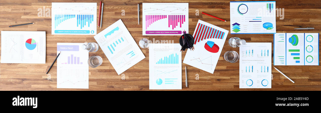 Paper with business chart on wooden office table Stock Photo - Alamy