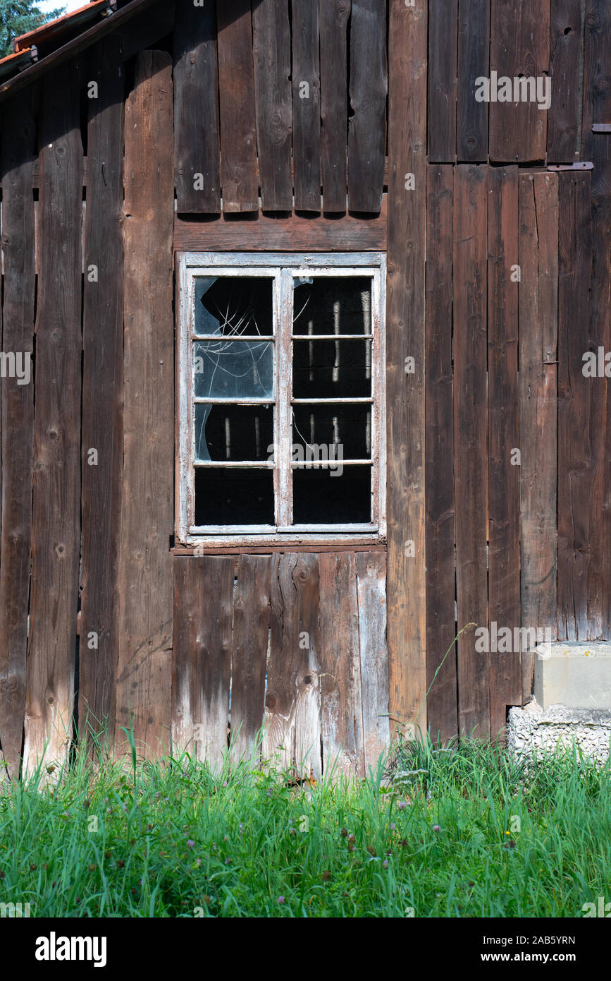 Broken window in an abandoned weathered shed Stock Photo - Alamy