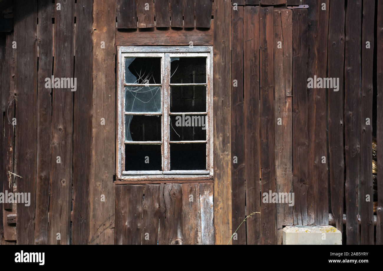 Broken window in an abandoned weathered shed Stock Photo - Alamy