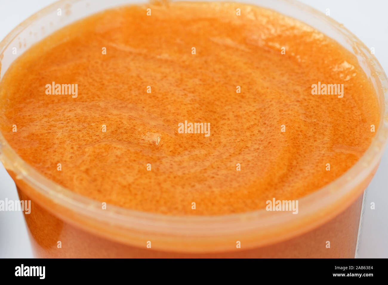 Body scrub in a plastic container. Orange scrub with cane sugar and ...