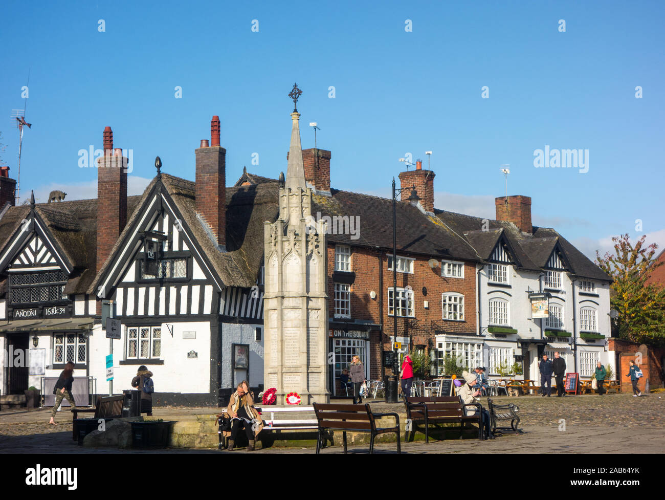 People sitting in the ancient cobbled market square in the Cheshire ...