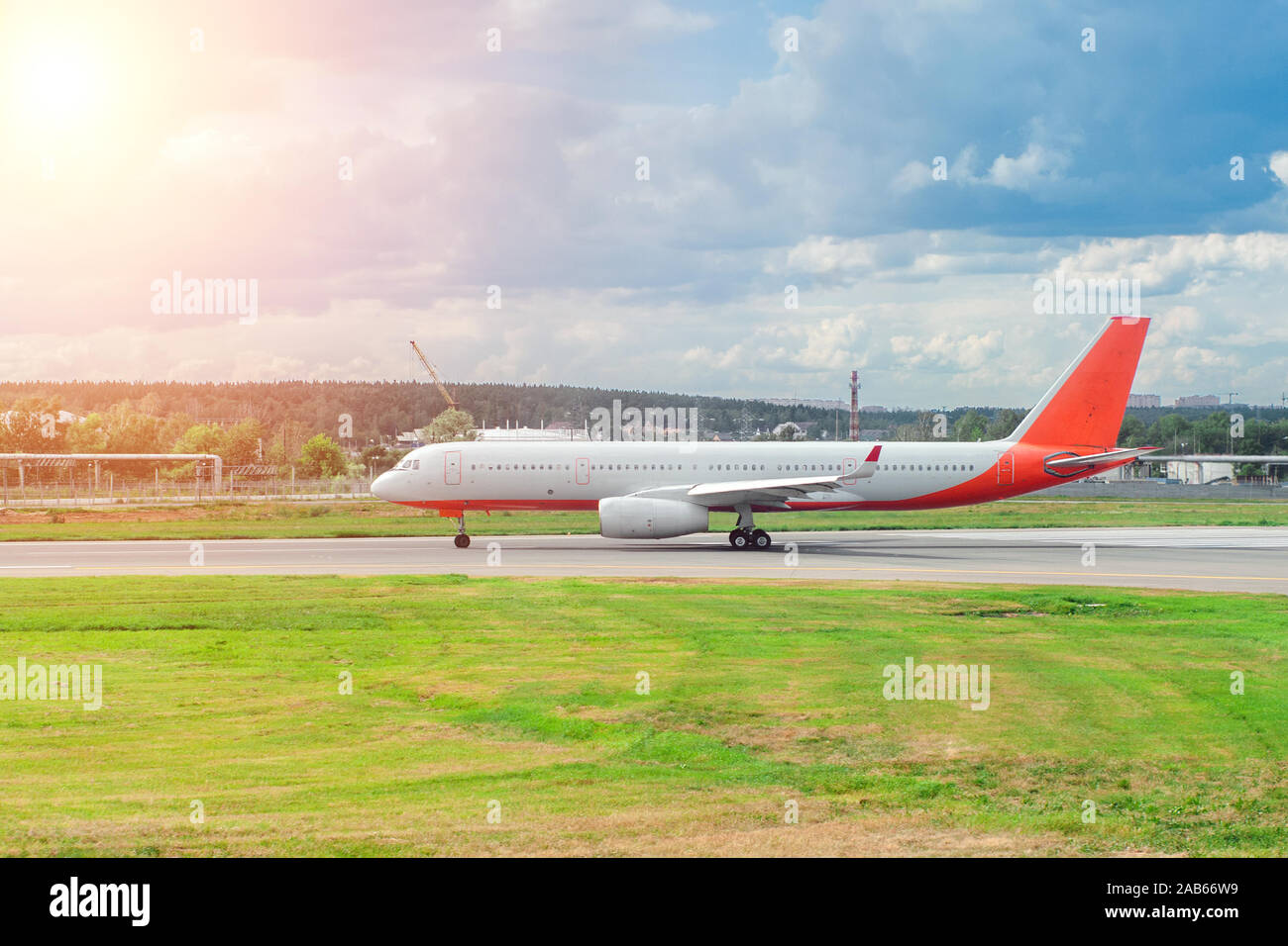 a white with a red tail passenger plane is ready to take off against ...
