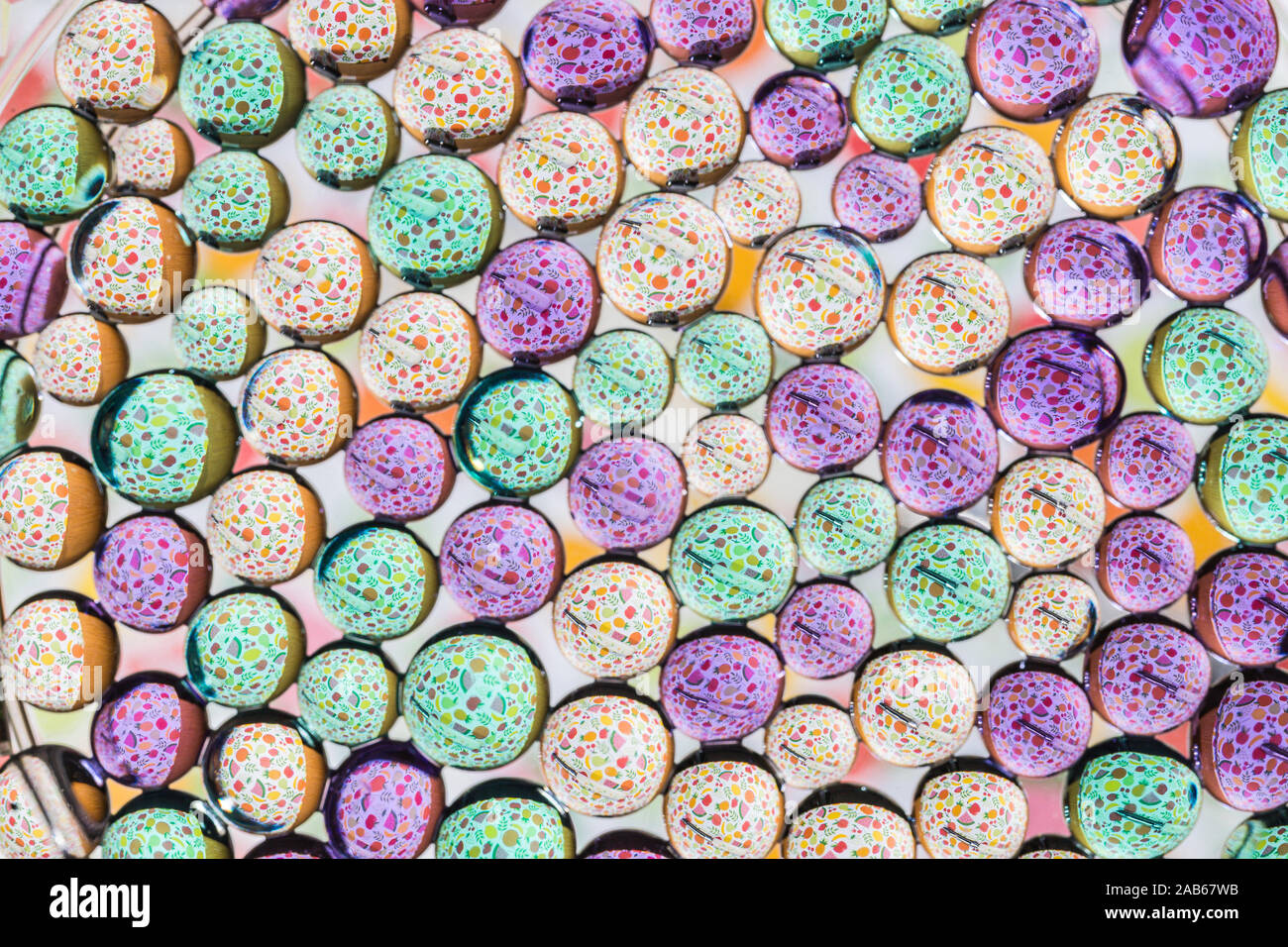 vegetable peeler refracted through marble-sized spheres as background ...