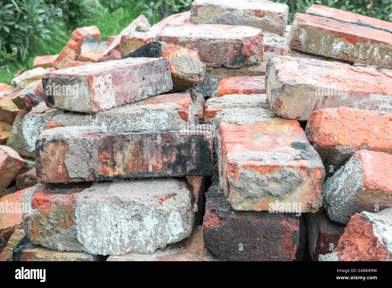 Many old used broken dirty burnt bricks with remnants of cement are ...