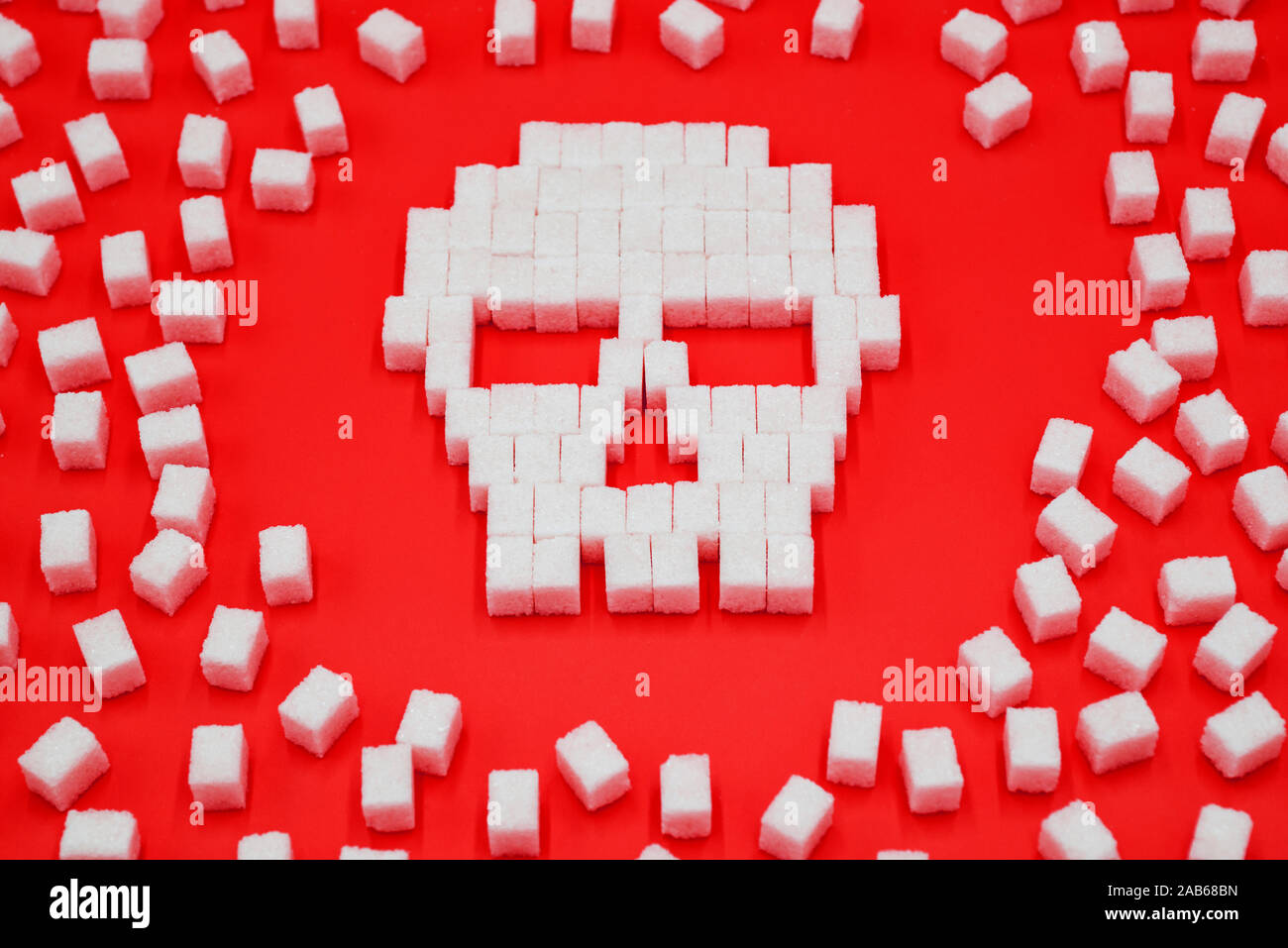 Sugar cubes laid out in shape of skull. Concept that sugar and sweets ...
