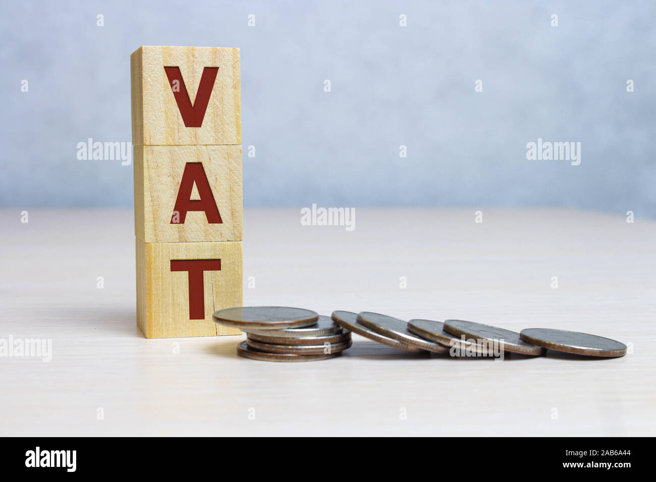 Vat on wooden cubes over blue background, financial concept background ...