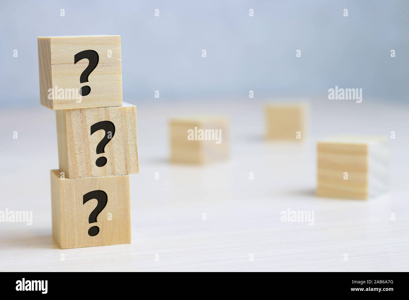Wooden cube block shape with sign question mark symbol on wood table ...