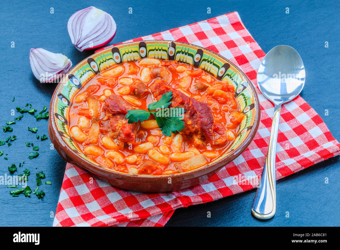Beans stew with meat and tomato sauce on black background with red ...