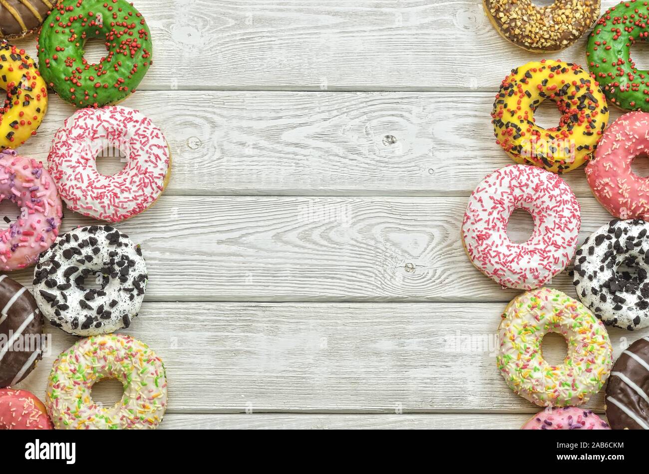 Background with colorful sweet cakes. Donuts with a hole with different ...