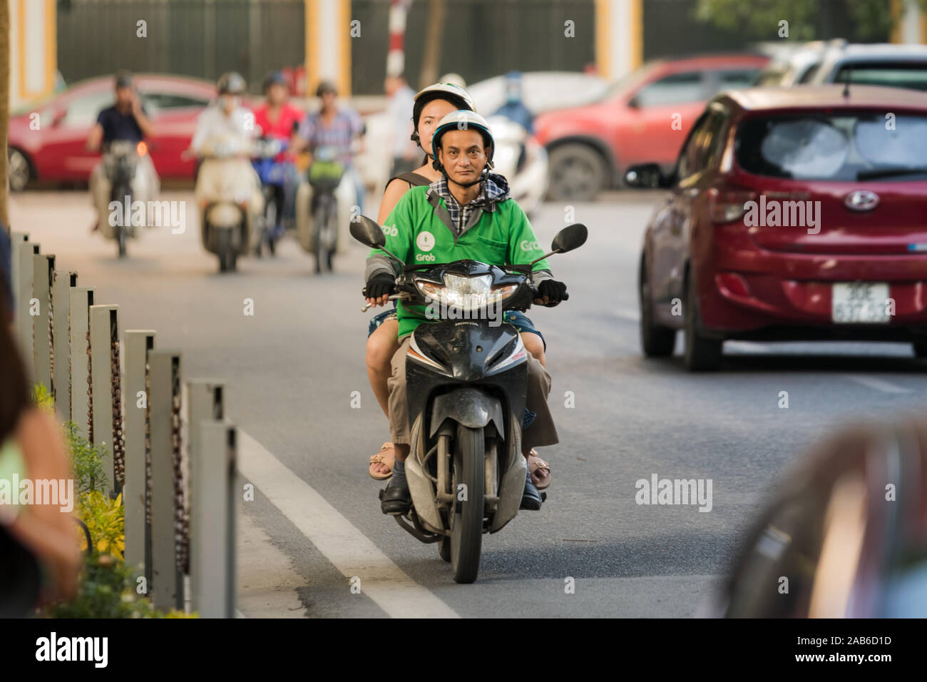 Hanoi, Vietnam - 11th October 2019: A male Grab rider takes female ...