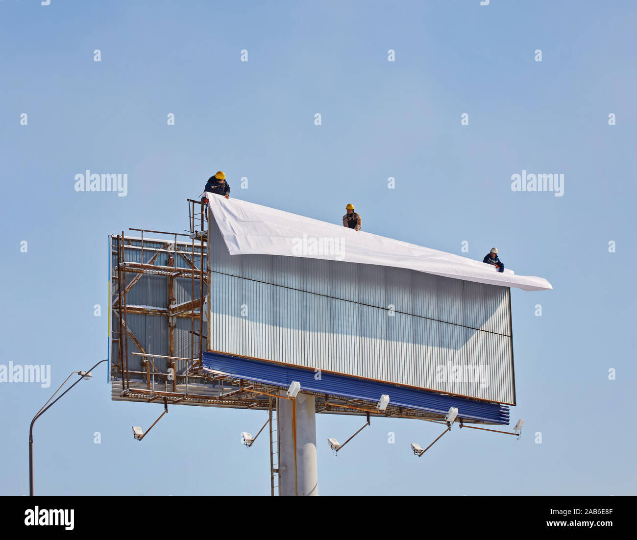 Worker prepares billboard to installing new advertisement. Industrial ...