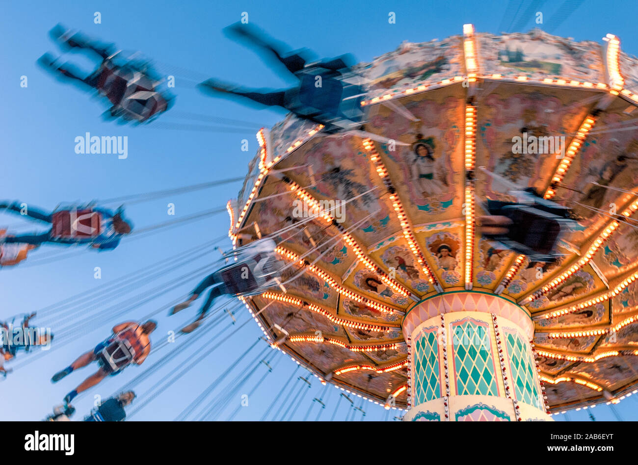 Amusement park motion blurred carousel riders on retro vintage tilting ...
