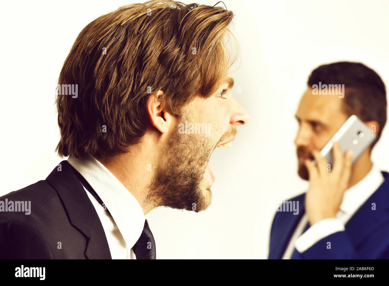 man shouting to busy businessman speaking on phone in formal suit ...
