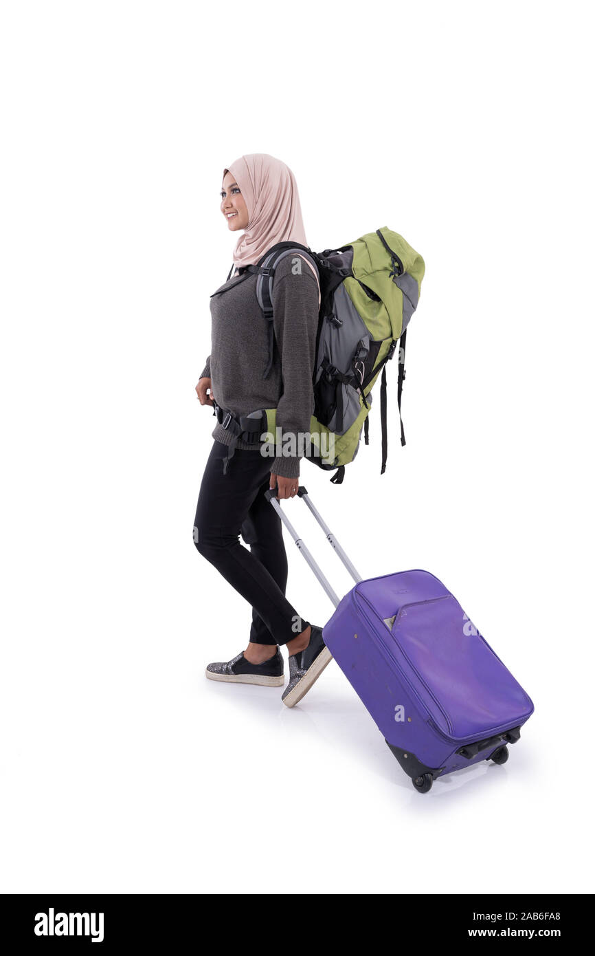 Hijab traveller walking with suitcase and carrying a backpack Stock ...