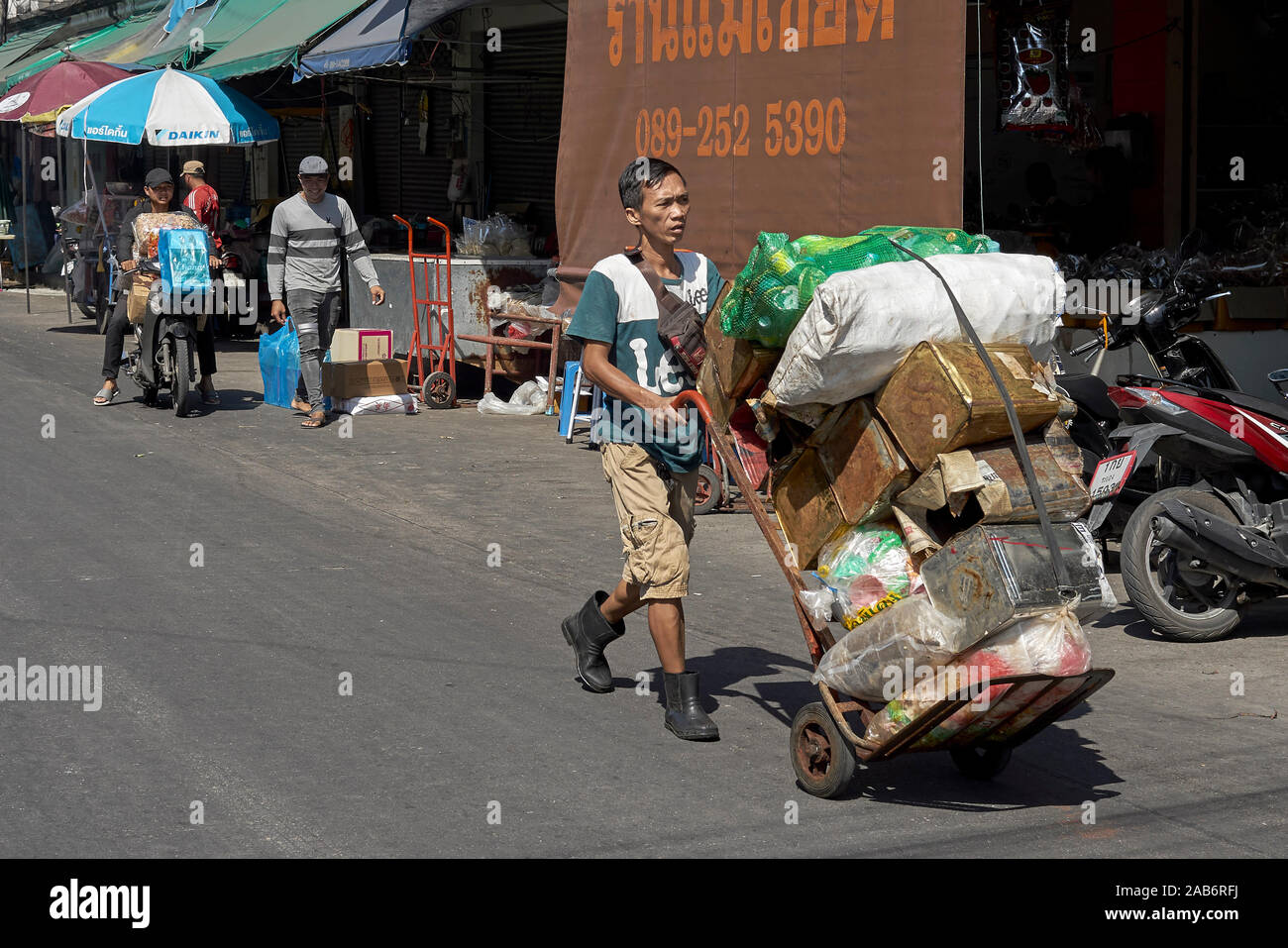Hand cart delivery. Thailand street scene with working man transporting ...