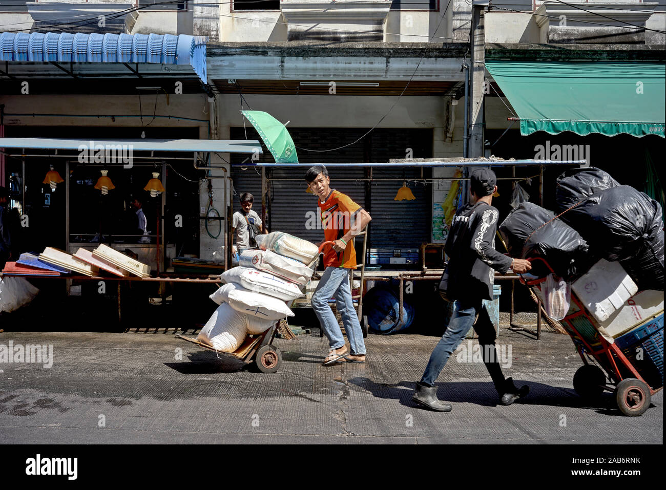 Hand cart delivery. Thailand street scene with working men transporting ...