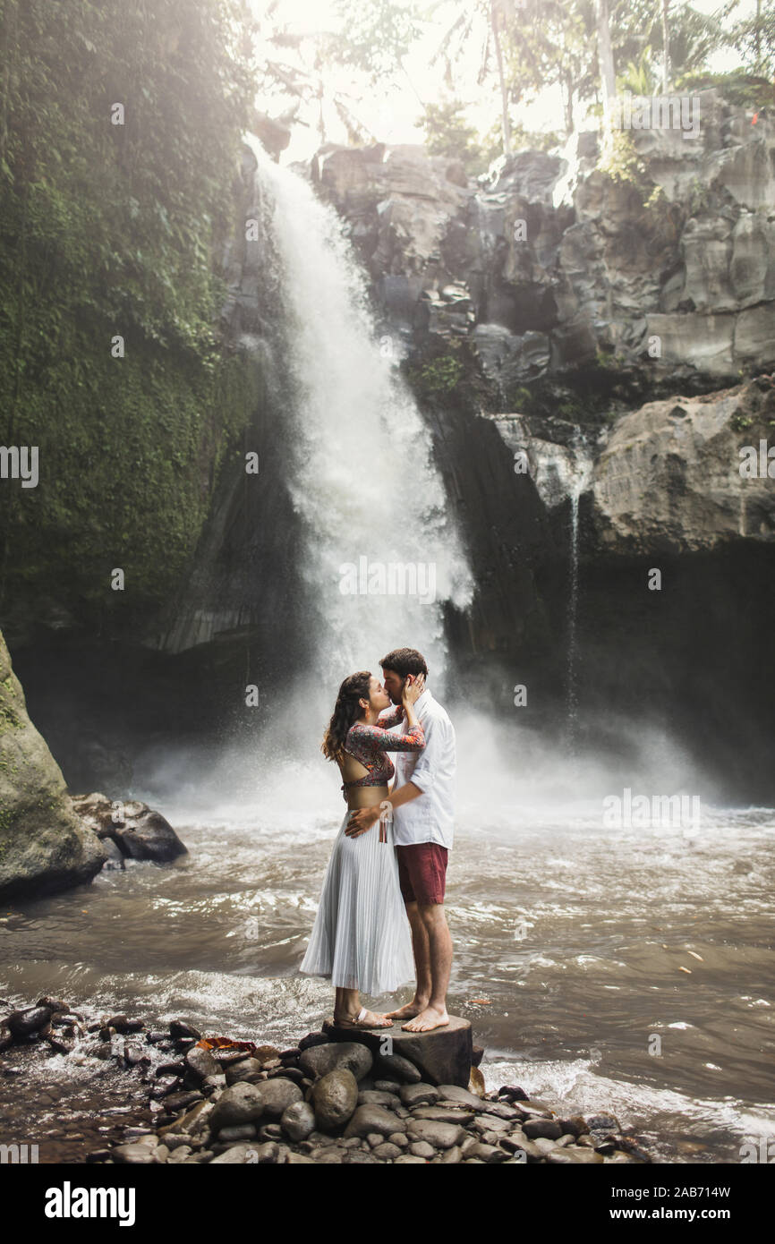 Spanish couple in love kissing with amazing view of waterfall. Happy ...