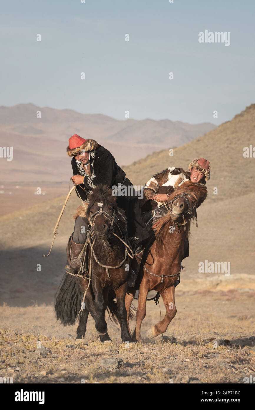Kazakh eagle hunters partaking in a traditional wrestling match. Two ...