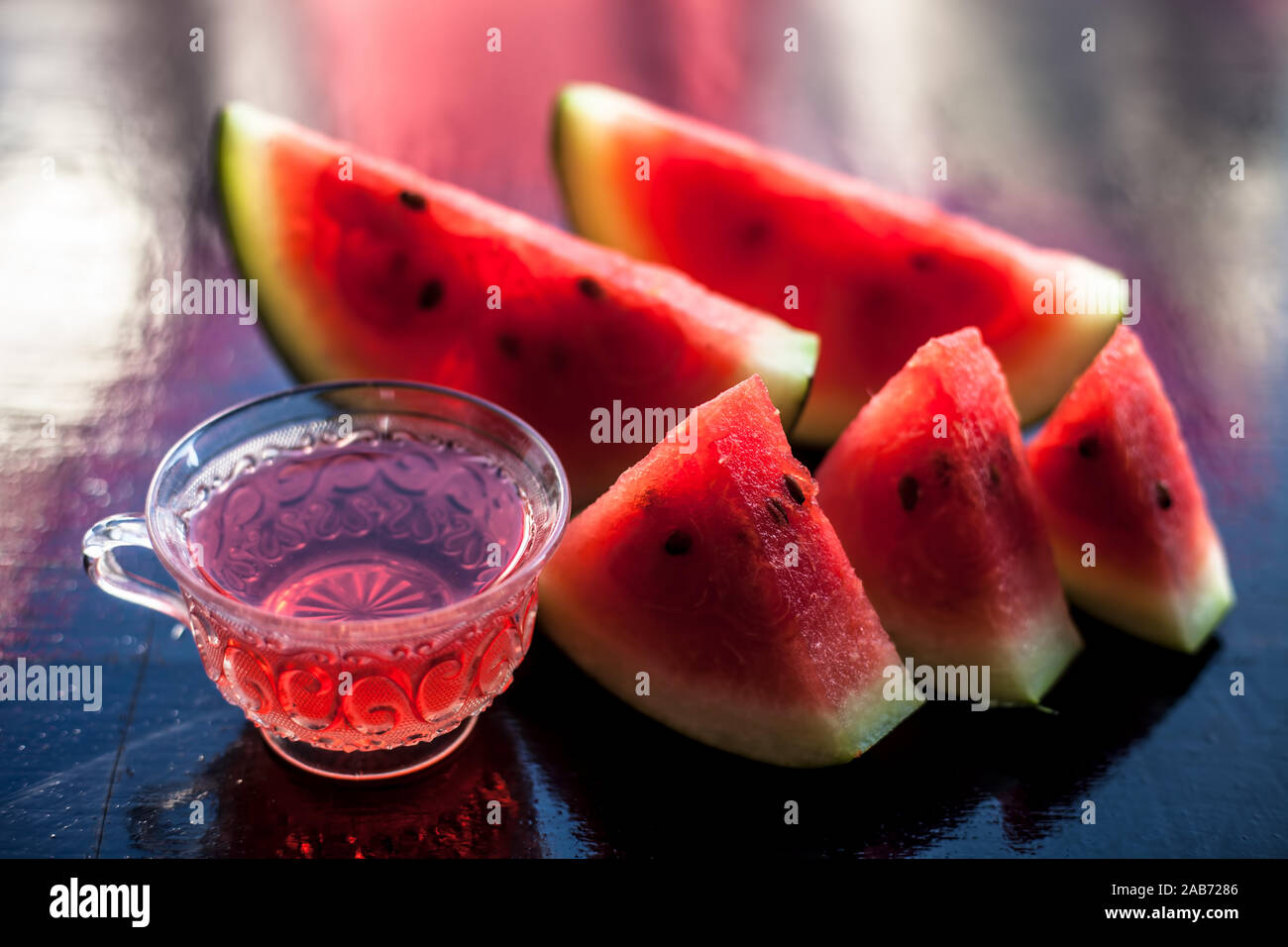 Mouth-watering watermelon tea in a transparent glass cup on wooden ...