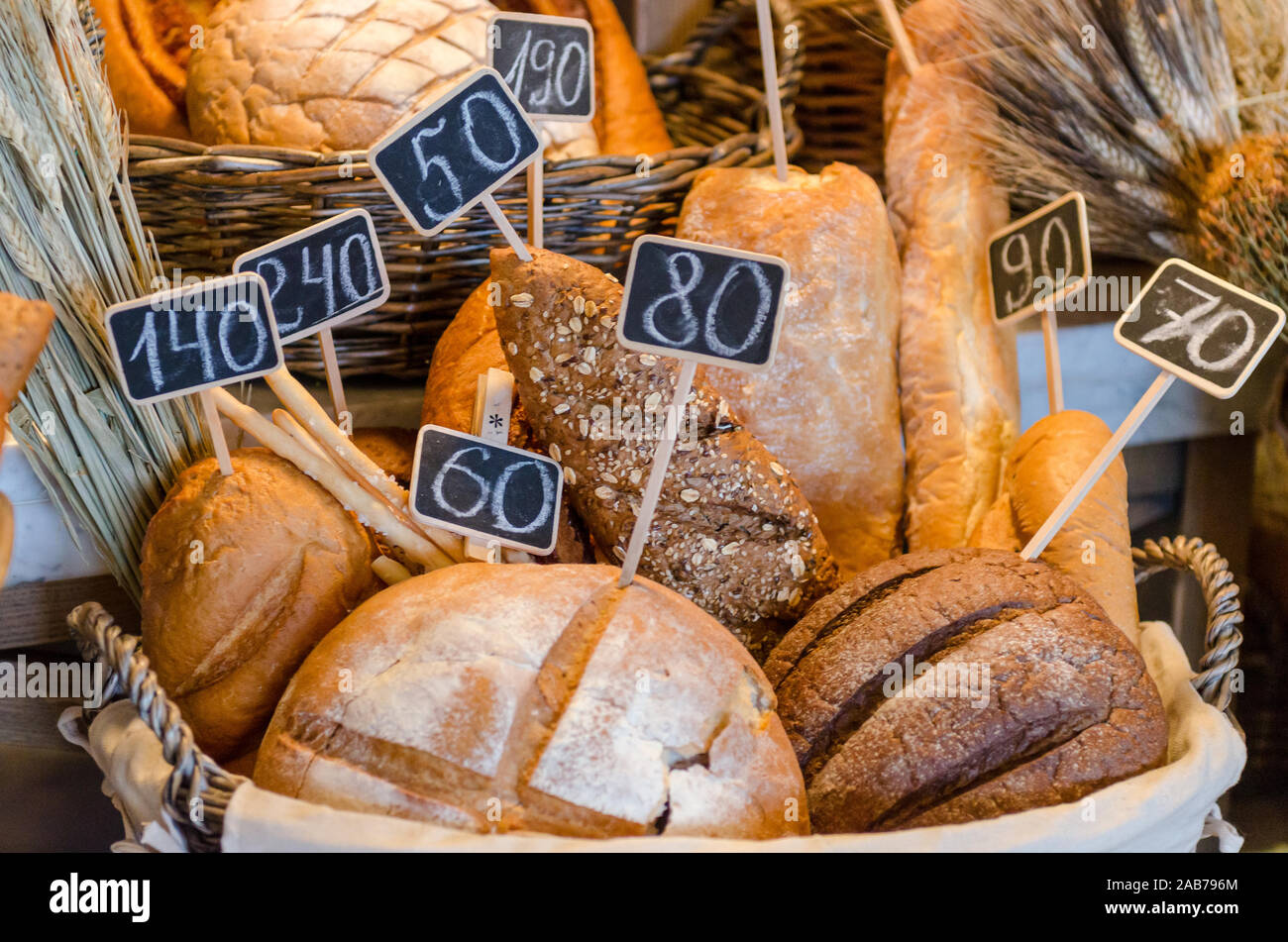 Basket with lots of various bread bagels and pastry. Price tags Stock ...