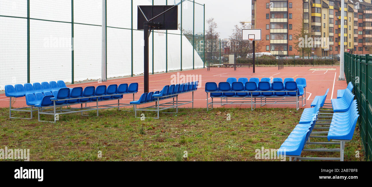 Blue plastic benches on metal frames near the new modern basketball ...