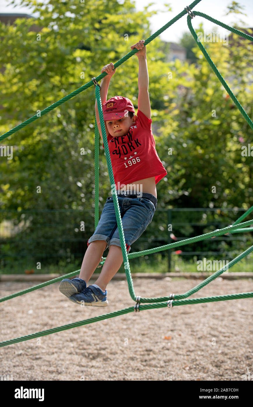 Young boy climbing on a spider web Stock Photo - Alamy