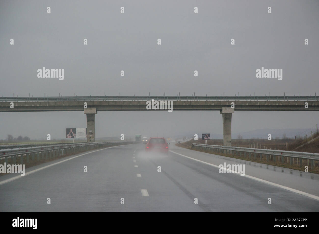 Passing under a bridge on an highway, rainy days, car driving through ...